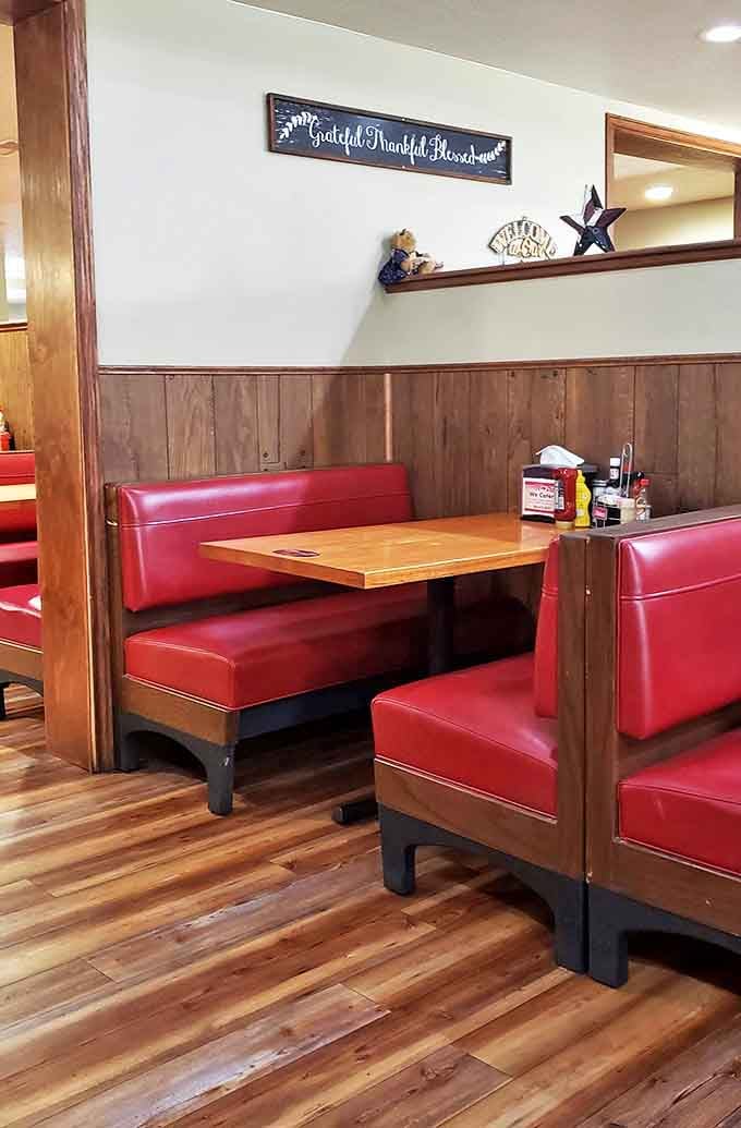 Classic red vinyl booths and wood-paneled walls create that perfect diner atmosphere where comfort begins before the food even arrives.