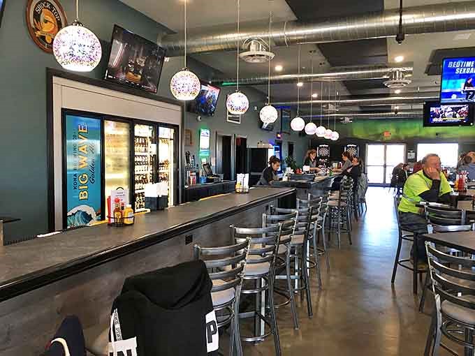 Inside, industrial-chic meets Midwest comfort with spherical pendant lights illuminating a bar where strangers become friends over burgers and beers.