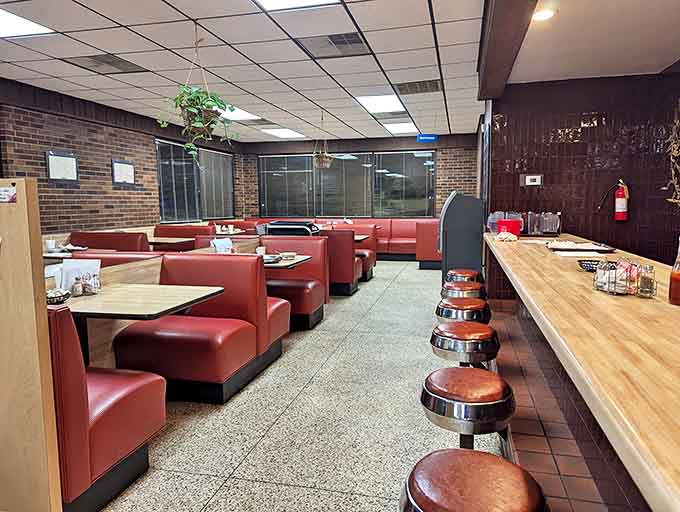 Classic red vinyl booths and counter seating – where strangers become friends over coffee and conversations about whether hash browns should be crispy or soft.