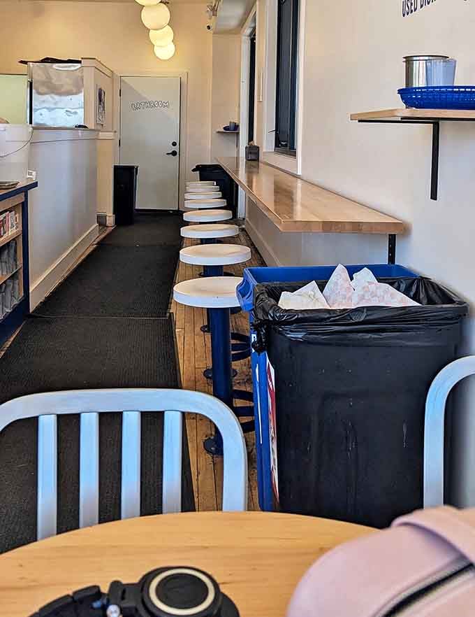 Minimalist chic meets maximum flavor potential. Those white stools aren't just seating&mdash;they're front-row tickets to the sandwich show.