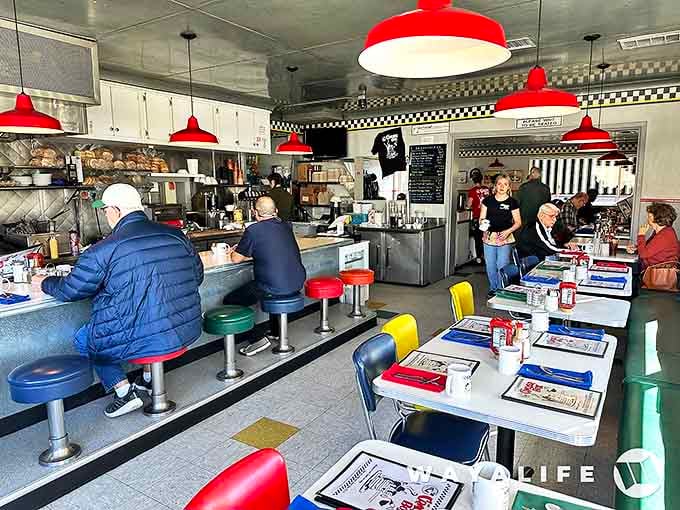Classic diner perfection awaits inside with red pendant lights, checkered trim, and colorful chairs that haven't changed since the Reagan era.