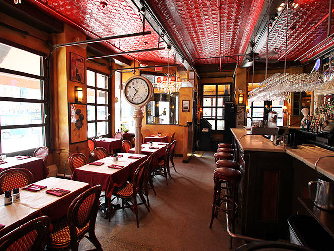 That crimson tin ceiling and warm wood interior transport you straight to Paris, minus the jet lag and language barrier.