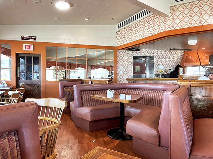 Pink vinyl booths and warm wood paneling create that perfect old-school diner atmosphere where conversations flow as freely as the coffee.