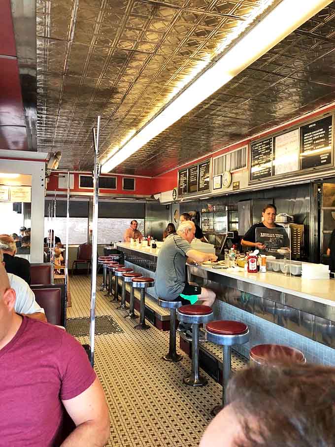 The heart of any great diner is its counter. Angelo's classic red vinyl stools and pressed tin ceiling create the perfect stage for breakfast theater.