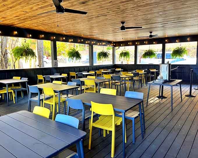Bright yellow and blue chairs pop against wooden ceilings in this airy dining space, where hanging plants create an atmosphere that's equal parts treehouse and trendy eatery.