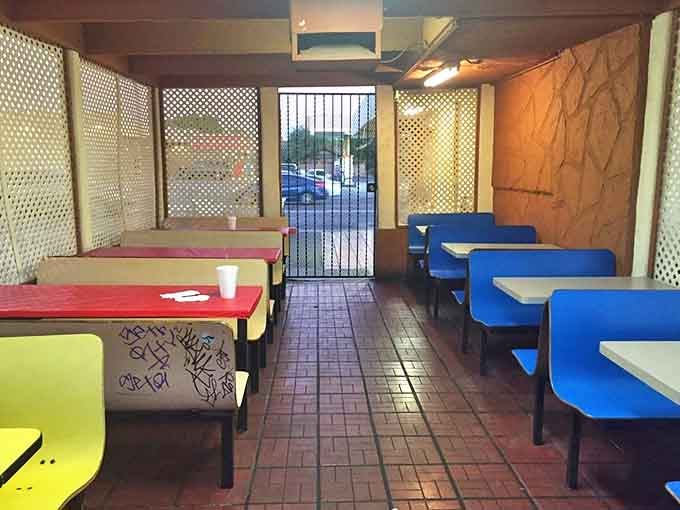 Simple tables in primary colors and latticed dividers create a no-nonsense dining space where the food, not the decor, takes center stage.