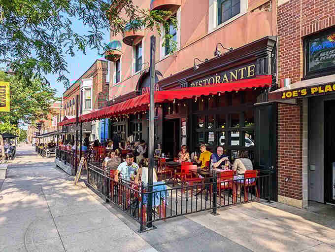 Basta's vibrant red patio seating invites you to enjoy pizza al fresco, turning an ordinary meal into a sidewalk celebration.