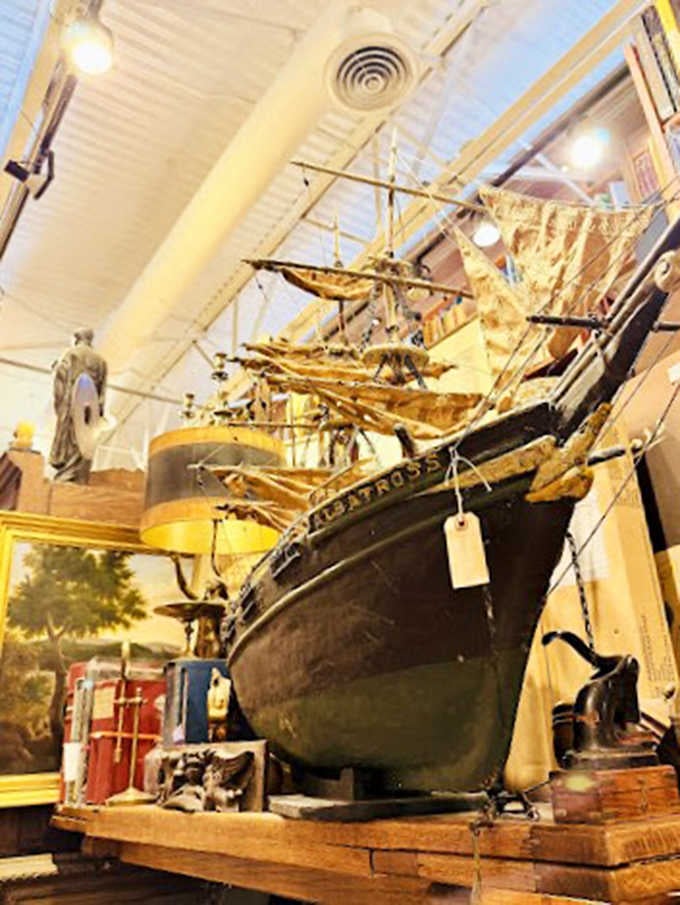 Not just books&mdash;this meticulously crafted ship model sails above the shelves, a reminder that both vessels transport us to distant worlds.