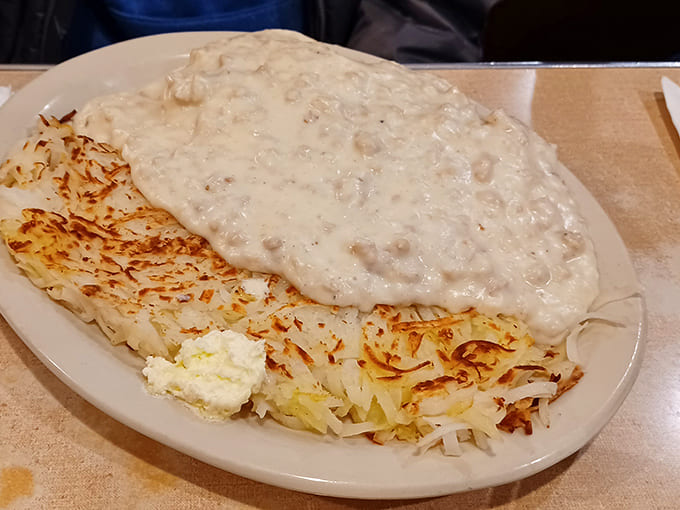 Behold the crown jewel: hashbrowns crisped to golden perfection, smothered in a creamy sausage gravy that could make a grown Minnesotan weep with joy.