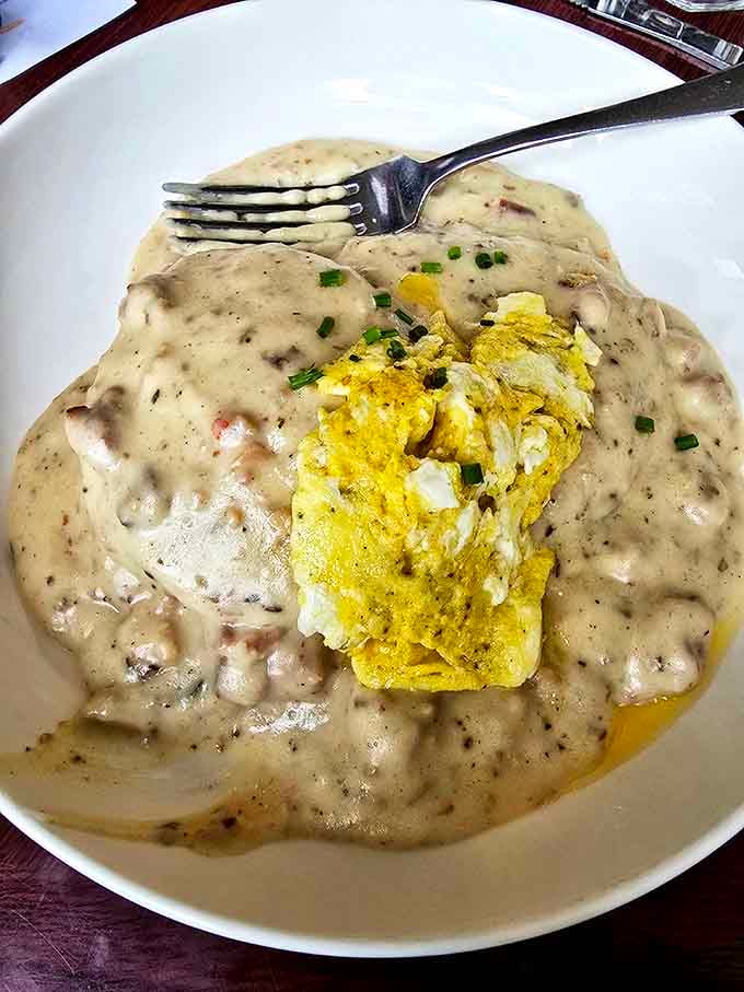 Behold the holy grail of comfort food: biscuits smothered in gravy with eggs nestled in the middle like treasure in a delicious, peppery sea.