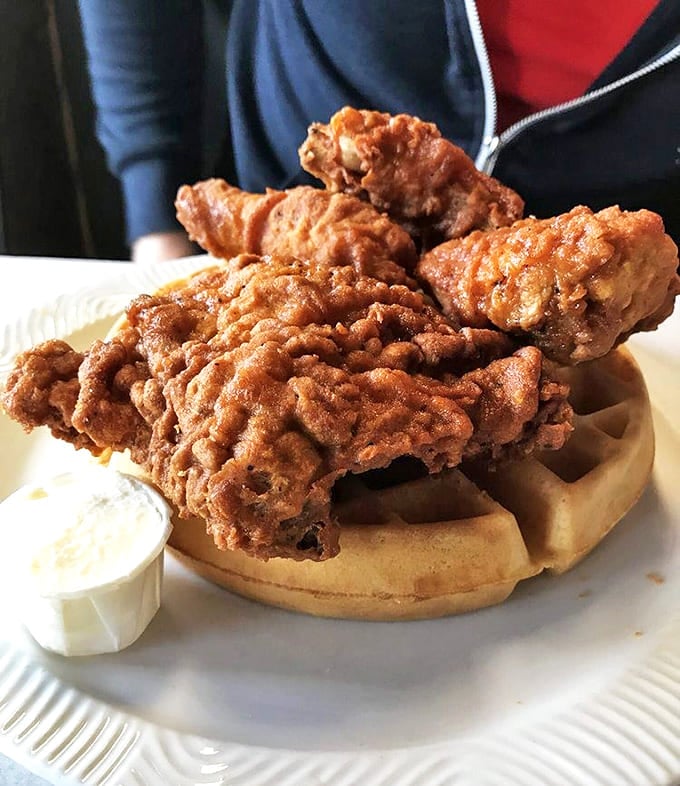 Chicken and waffles: where breakfast and dinner collide in perfect harmony. That golden-brown chicken perched atop a waffle is comfort food engineering at its finest.