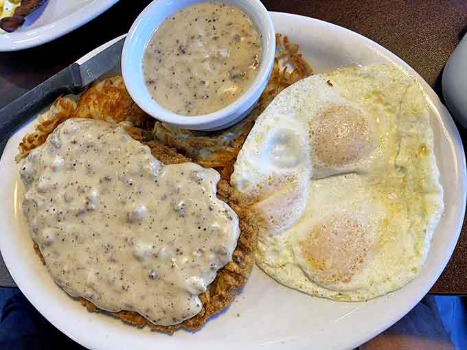 Behold the legendary chicken fried steak in its natural habitat &ndash; smothered in gravy with eggs standing guard nearby.