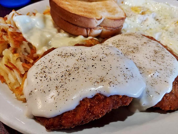 Chicken fried steak smothered in pepper-flecked gravy that cascades down the sides like a savory waterfall&mdash;this is breakfast with purpose.