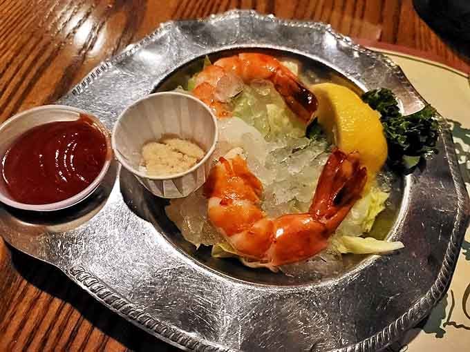 Behold the star attraction—jumbo shrimp perched on a silver platter like ocean royalty, waiting for their horseradish-spiked cocktail sauce bath.