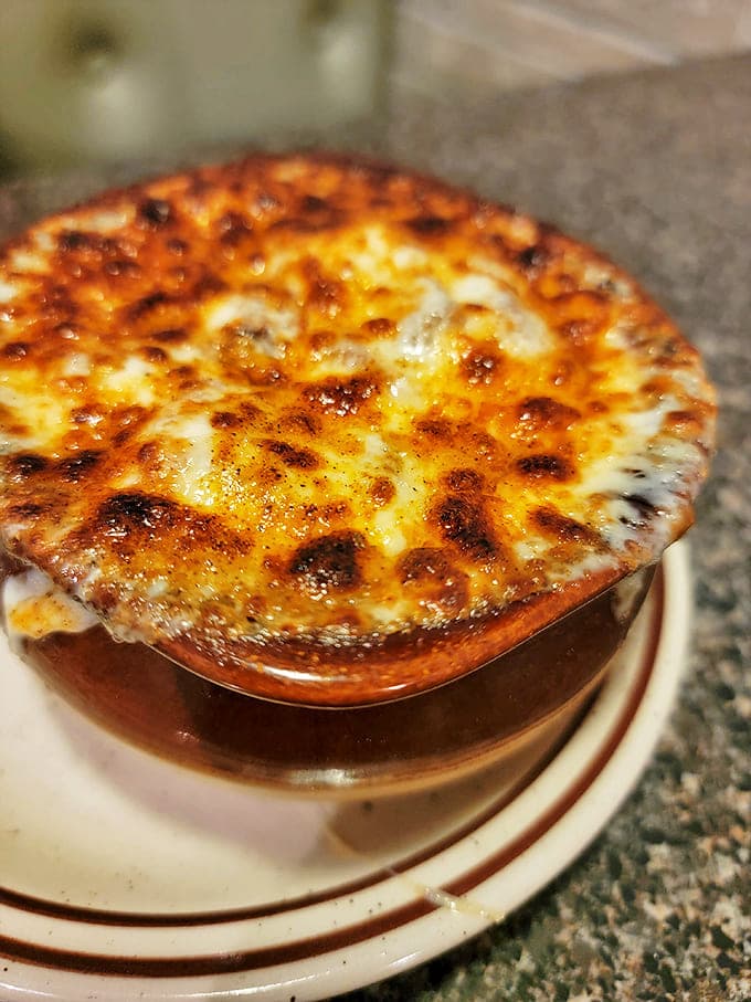 This French onion soup isn't messing around&mdash;that golden crown of melted cheese is sealed to the crock like it's protecting buried treasure underneath.