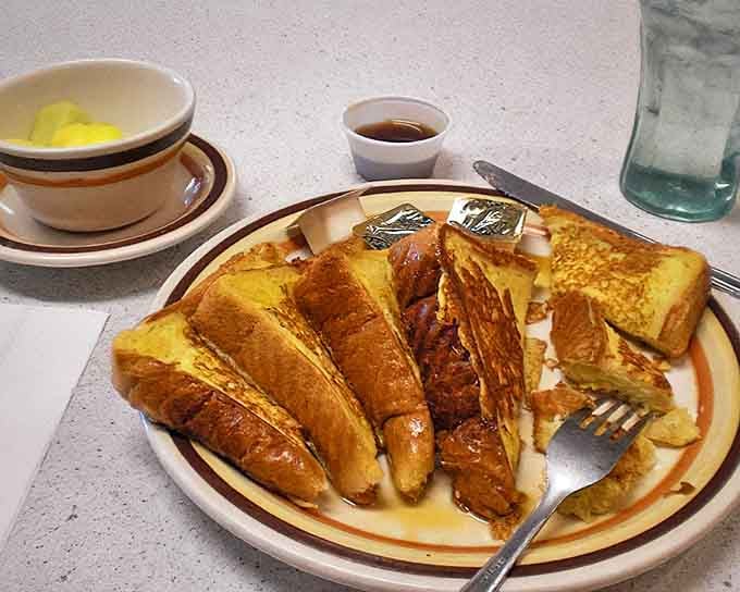 French toast that's achieved that mythical balance: crispy edges, custardy centers, and enough maple syrup to make a Canadian jealous.