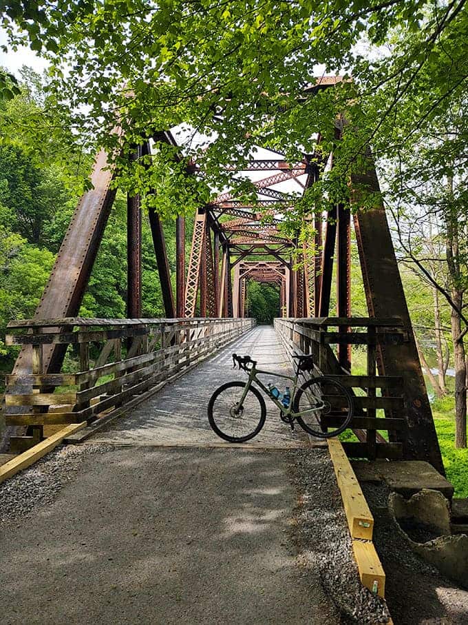 Engineering meets enchantment on the Greenbrier River Trail bridge, where rusted steel trusses frame adventures waiting just beyond your handlebars.