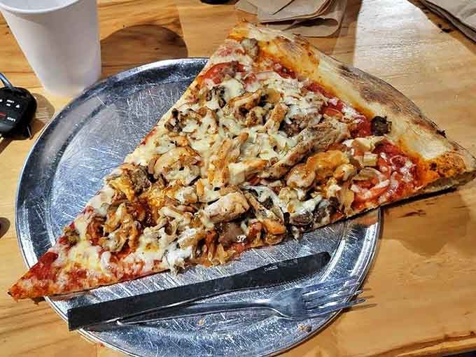 This isn't just a pizza slice &ndash; it's a topographical map of flavor country, where chicken and cheese create delicious mountain ranges.