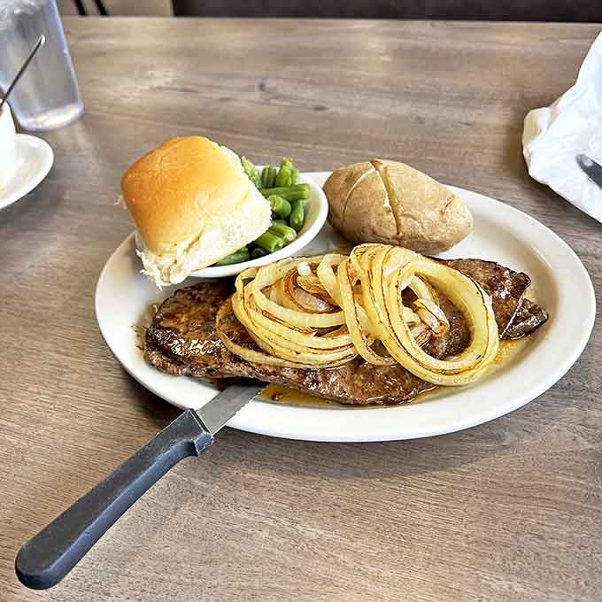 Steak with perfect grill marks and curled onions that dance across the top&mdash;proof that simple food done right is culinary poetry.