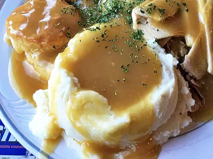 Behold the star attraction: mashed potatoes drowning in golden gravy alongside tender turkey. This plate has launched a thousand road trips.
