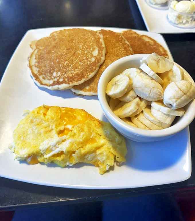 Breakfast perfection on a plate: golden pancakes with a side of sunshine-yellow eggs and fresh bananas. Morning glory, indeed!