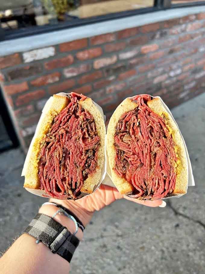 Not just a sandwich, but an engineering marvel of perfectly stacked pastrami. The meat-to-bread ratio here deserves its own mathematical equation.