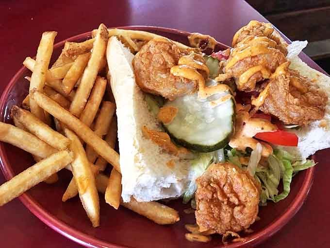 The legendary Po Boy arrives like a crispy, golden celebrity on a plate, with French fries standing by as worthy supporting actors.
