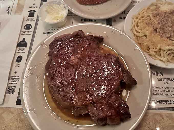 Behold the star of the show: a glistening ribeye bathed in that signature Greek-style butter sauce that's worth crossing state lines for.