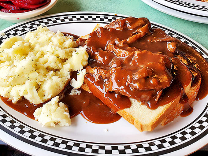 Hot turkey sandwich perfection&mdash;bread islands drowning happily in a gravy sea. Those mashed potatoes aren't just a side dish; they're a life philosophy.