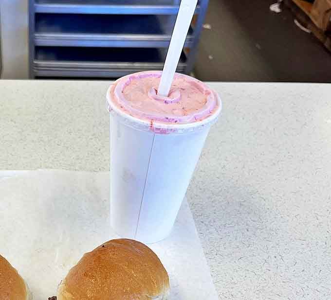 That strawberry shake isn't just a beverage; it's a creamy pink promise of happiness served in an unpretentious paper cup.