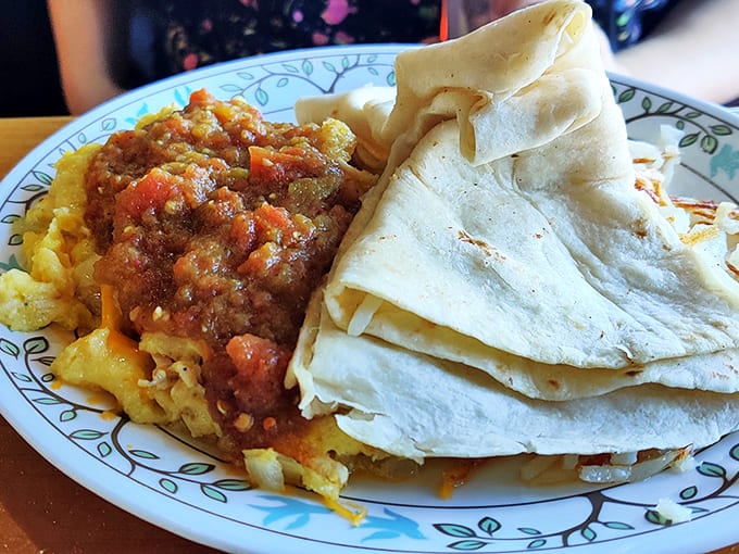 Breakfast nirvana arrives as hash browns meet spicy salsa and tortillas—a mountain-sized portion that makes you question if you'll need lunch today.