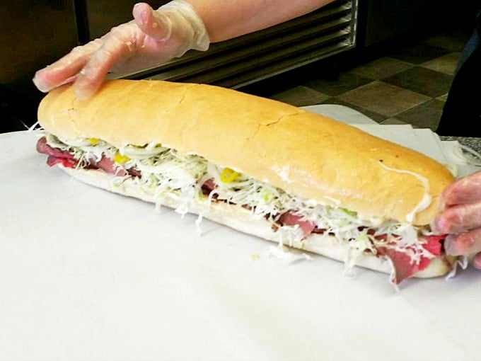 Hands crafting culinary magic&mdash;this isn't just sandwich assembly, it's architecture where every ingredient finds its perfect place.