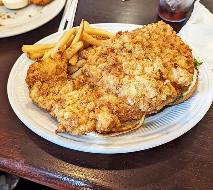 The legendary tenderloin sandwich arrives with a passport-worthy overhang&mdash;a crispy-breaded masterpiece that makes the bun look like it's playing a supporting role.