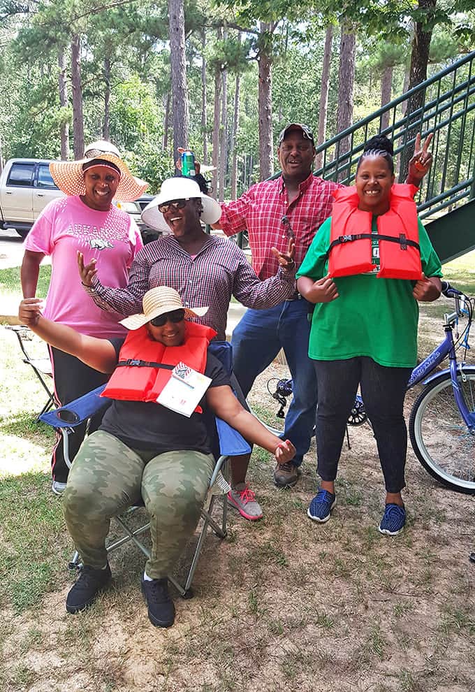 Nothing says "outdoor adventure" quite like friends in life vests ready to conquer the water. The smiles say it all &ndash; nature brings people together.