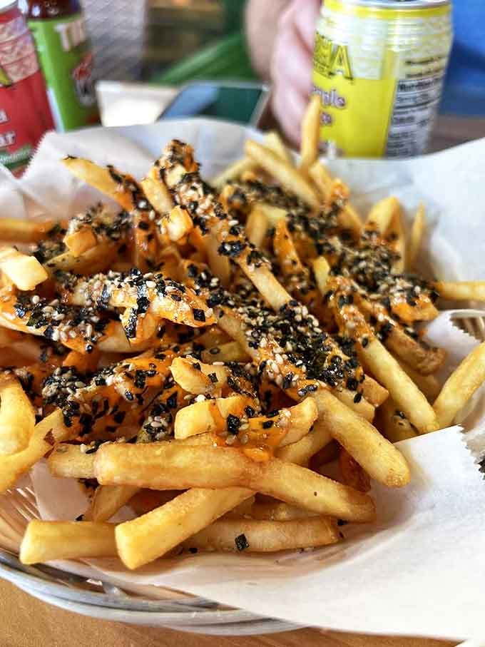 These Volcano Fries erupt with flavor, not lava. Sesame seeds scattered like tiny flavor grenades across a landscape of perfectly crisp potatoes.
