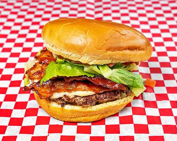 Behold burger perfection: a golden bun cradling a juicy patty, crisp bacon, and fresh lettuce&mdash;architecture so beautiful it deserves its own zip code.