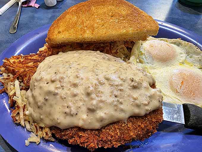 Chicken fried steak smothered in gravy that could make a vegetarian question their life choices, with eggs standing by as willing accomplices.