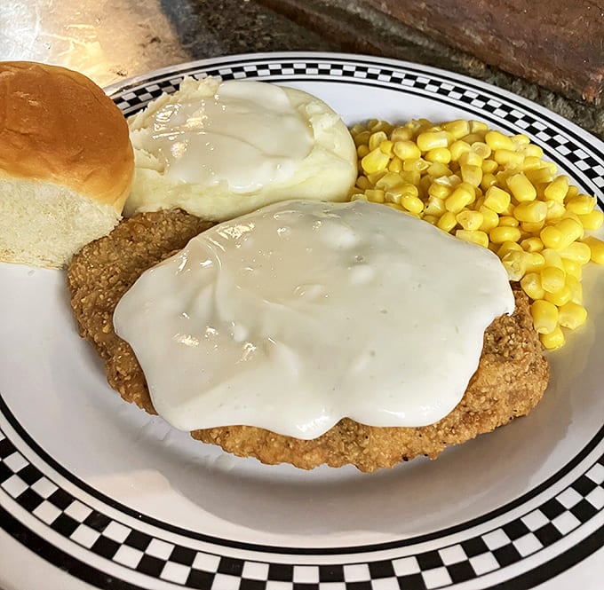 Behold the star of our show: chicken fried steak swimming in gravy so good you'll want to write poetry about it. Vegetables included for plausible deniability.