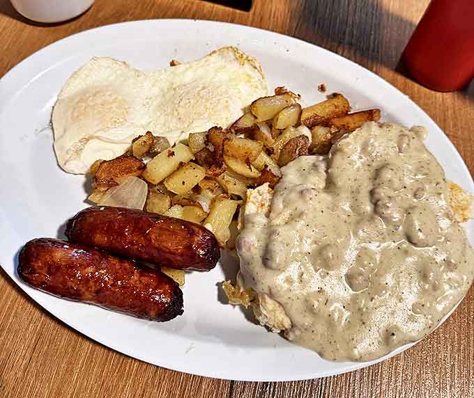 Breakfast nirvana achieved: golden sausages, perfectly seasoned potatoes, and eggs just how you want them, all smothered in country gravy that could make a vegetarian reconsider.