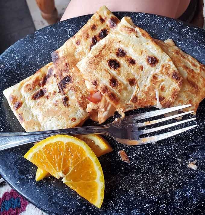 This savory crepe isn't just folded &ndash; it's architecturally designed to maximize the perfect bite-to-filling ratio. The orange slice adds a sunny hello.
