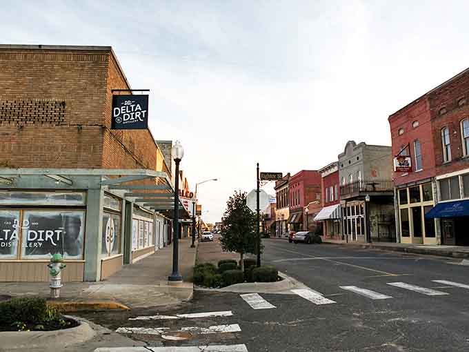 The Delta Dirt Distillery sign hints at Helena-West Helena's entrepreneurial spirit amid historic buildings and affordable living.