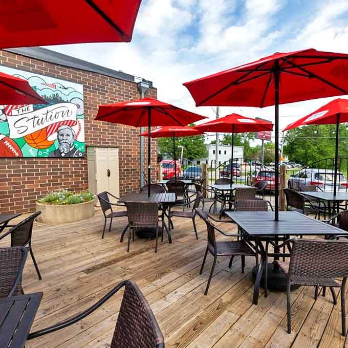 The Station's inviting patio beckons with those cherry-red umbrellas - a perfect spot to savor Des Moines' burger royalty.