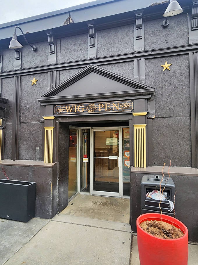 The mysterious black facade of Wig & Pen Pizza Pub beckons with golden stars and columns&mdash;like a secret pizza society headquarters.