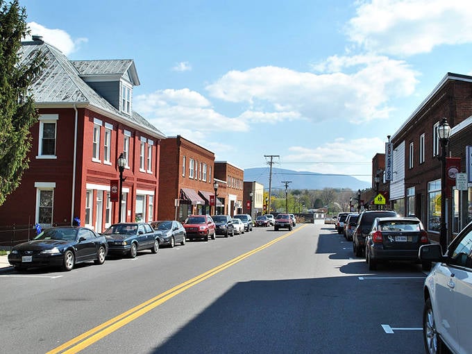 Red brick facades glow in afternoon light, creating warmth that radiates from every carefully preserved storefront.