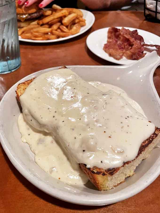 Biscuits and gravy that would make your grandmother nod in approval. That cream sauce isn't just covering the toast – it's embracing it.