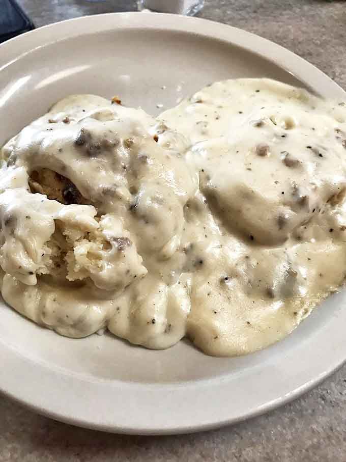 Biscuits swimming in creamy sausage gravy – the kind of comfort food that makes you want to hug the cook afterward.