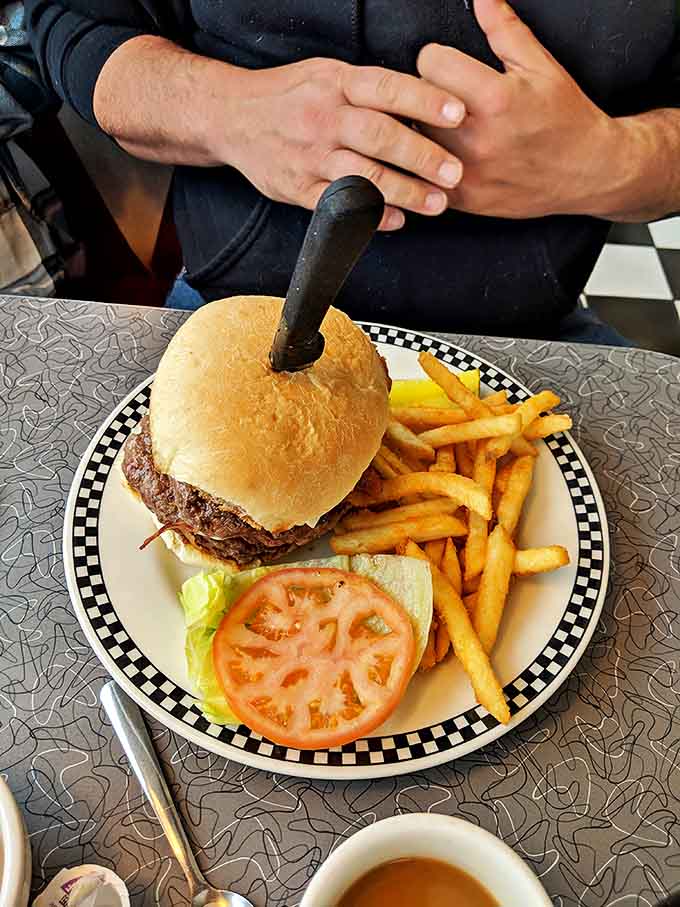 That knife stabbed through the burger isn't just for show&mdash;it's holding together a masterpiece of beef, cheese, and fresh toppings that demands respect.