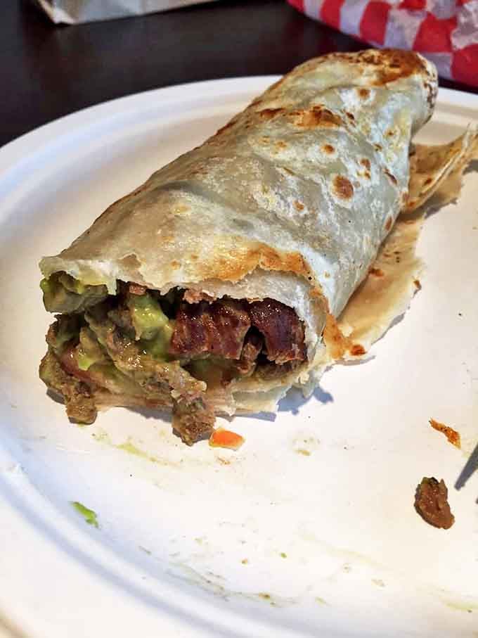 Not all heroes wear capes; some come wrapped in tortillas. This carne asada burrito delivers a symphony of textures that would make Mozart weep with joy.