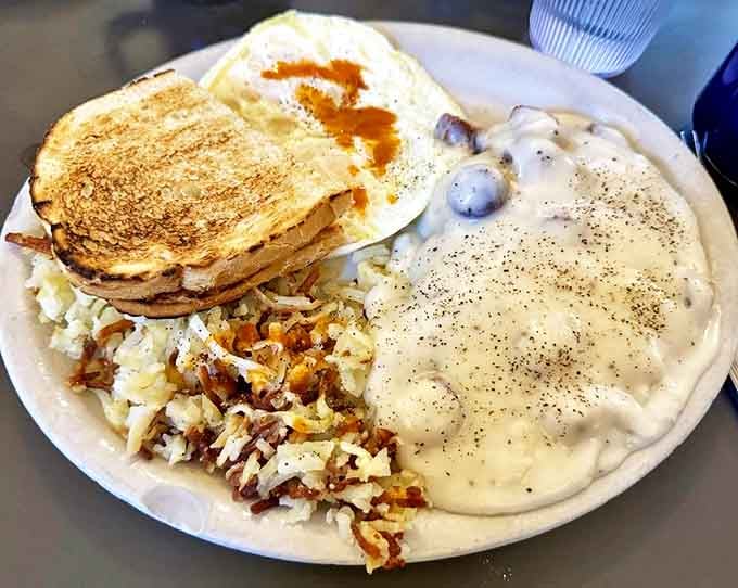 Breakfast alchemy at its finest: crispy toast, perfectly peppered gravy, and hash browns that crackle with each bite.