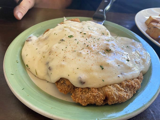 Chicken fried steak swimming in creamy gravy. The kind of dish that makes you want to hug the chef afterward.